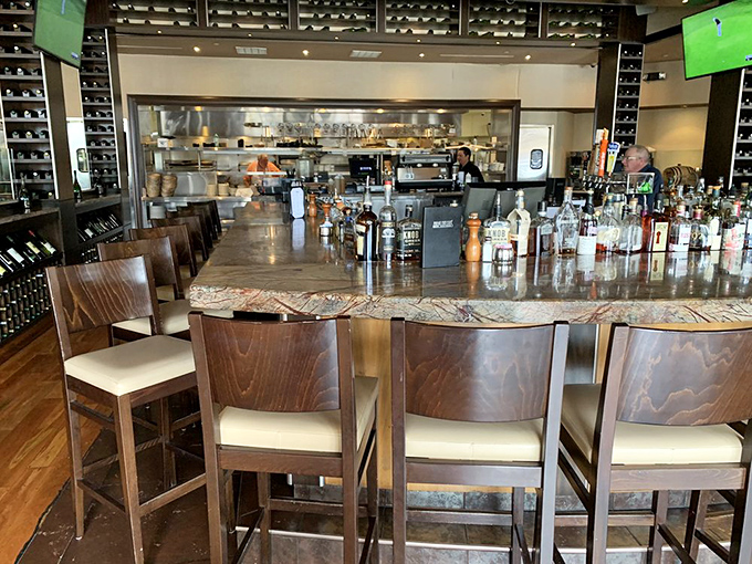 The bar beckons with its impressive display of bottles, promising liquid courage before you commit to ordering that 32-ounce tomahawk steak.