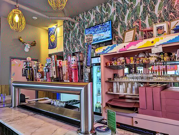 The bar area gleams with beer taps and tropical wallpaper, proving that donuts and drinks deserve a sophisticated setting.