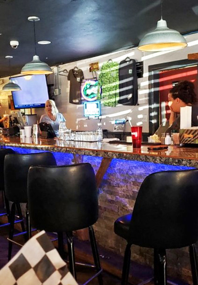 The bar glows with blue light and possibility. Where strangers become friends and the bartender might just know your name.