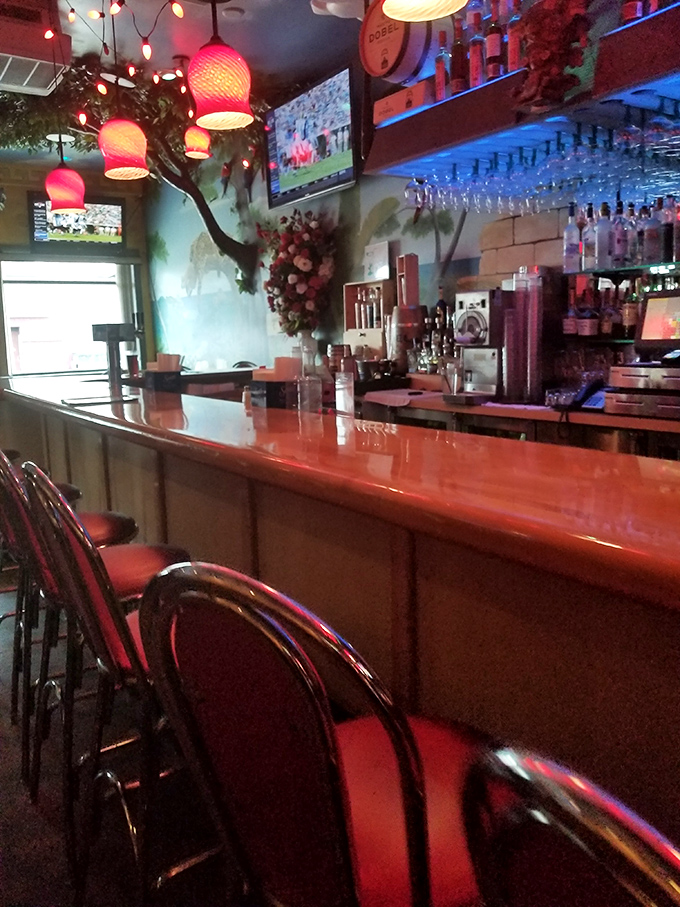 The bar at Botanas doesn't just serve drinks—it crafts liquid happiness under the glow of those distinctive red pendant lights. Tequila library, anyone?