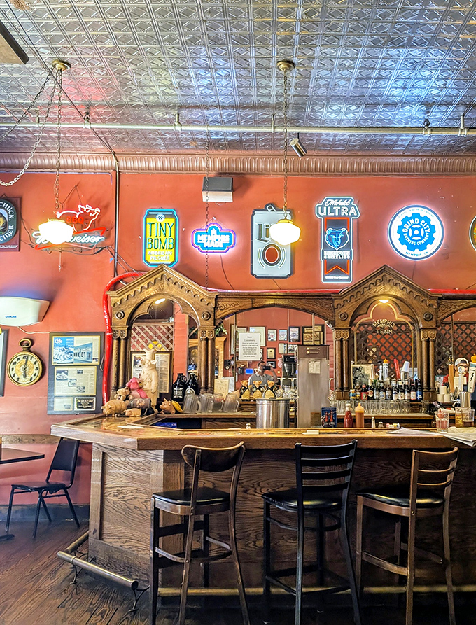 The bar area showcases Memphis pride with neon signs glowing against rustic wood, creating the perfect backdrop for cold drinks and barbecue debates.