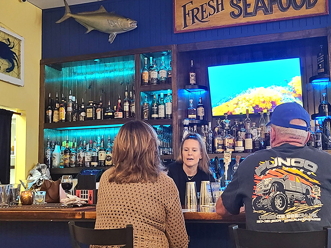 A bar stocked for serious cocktail crafting, not just obligatory beer pouring. That blue backlight makes everything feel like an underwater adventure.