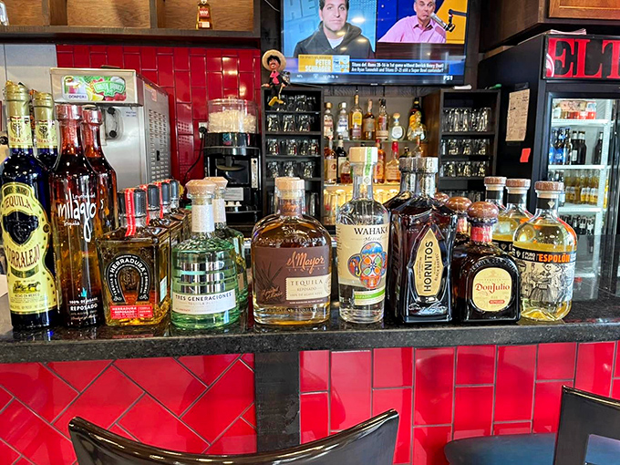 A tequila collection that deserves its own security detail. That red tile backsplash isn't just decorative&mdash;it's warning you things might get spicy.