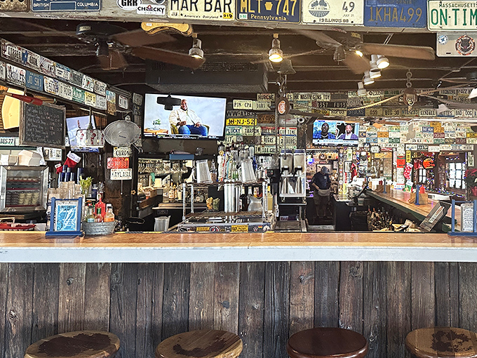 A bar that tells stories through its weathered wood and collected memorabilia. Each license plate represents a road that led someone here.