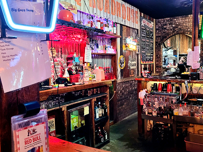 The bar area glows with neon promise. This is where sauce-stained fingers grip cold beers and BBQ theories are debated with scholarly intensity.