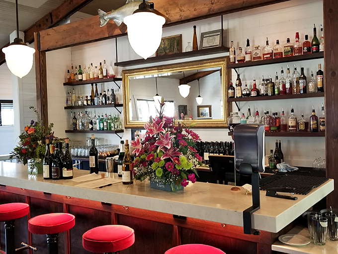 A bar stocked for serious business, with flowers that say, "Yes, we can make both an excellent Old Fashioned and your grandmother's favorite cocktail."