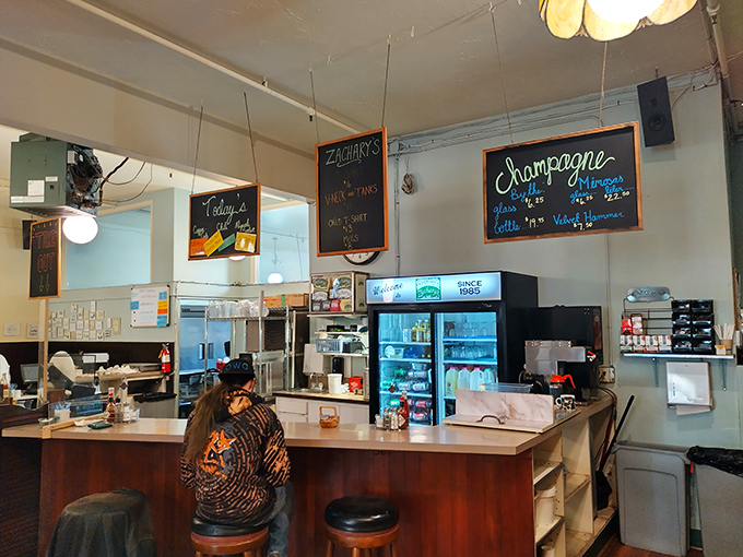 The counter where breakfast dreams come true. Those hanging chalkboard menus hint at specials worth abandoning your "usual" order for. 