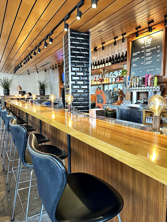 The bar isn't just serving drinks; it's showcasing craftsmanship with a wooden counter that practically begs for your elbows and stories.