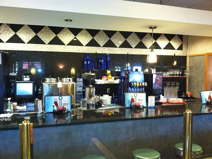 The classic diner counter where coffee flows freely and breakfast conversations create lasting neighborhood connections.