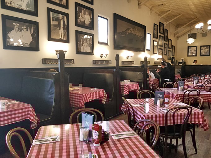 Dark wood booths lined with historical photos create intimate dining islands where conversations flow as freely as the coffee refills.