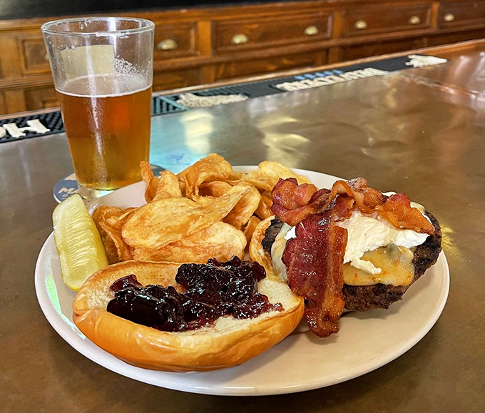 Beer's best friend: a perfectly crafted burger with house-made chips. The pickle spear stands guard like a crunchy sentinel of flavor.