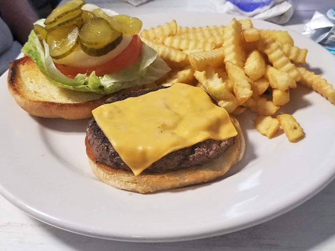 A cheeseburger that understands the assignment: melty American cheese, a substantial patty, and crinkle fries standing at attention.