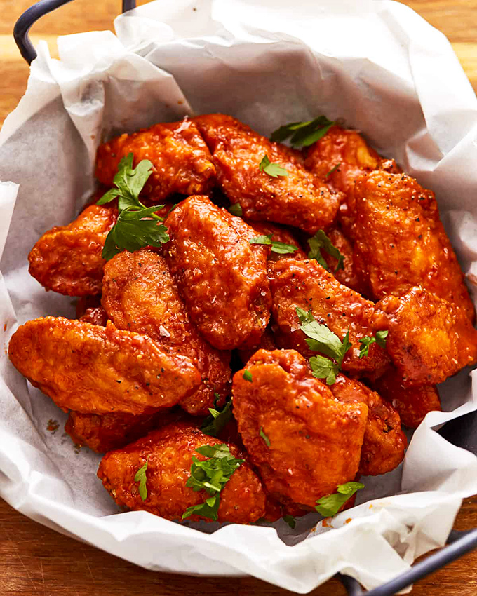 These wings aren't messing around&mdash;glossy with sauce and garnished with fresh herbs, they're the kind that silence conversation as everyone focuses on the next bite.