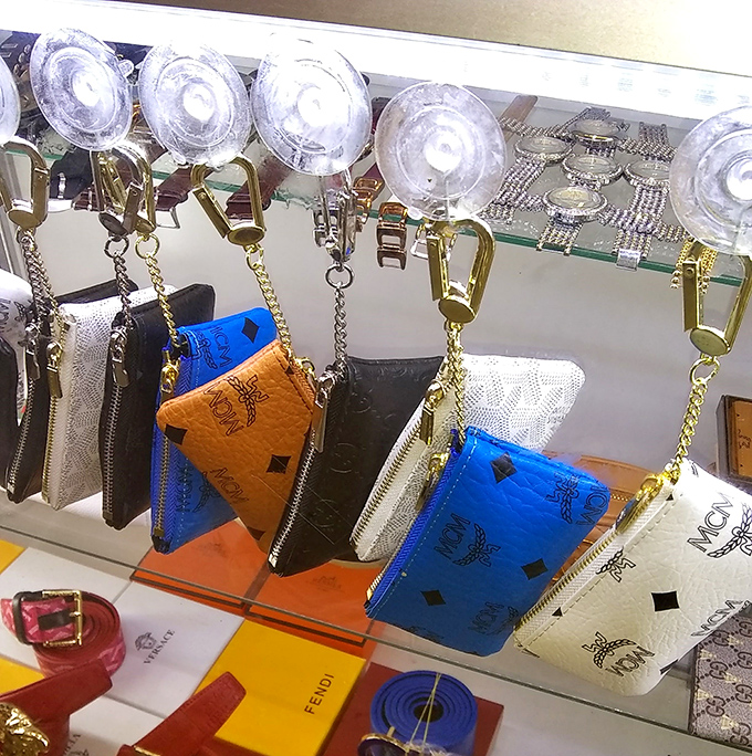 These designer-inspired coin purses and wallets hang like fashionable fruit, ready to be plucked by savvy shoppers with champagne taste and beer budgets.