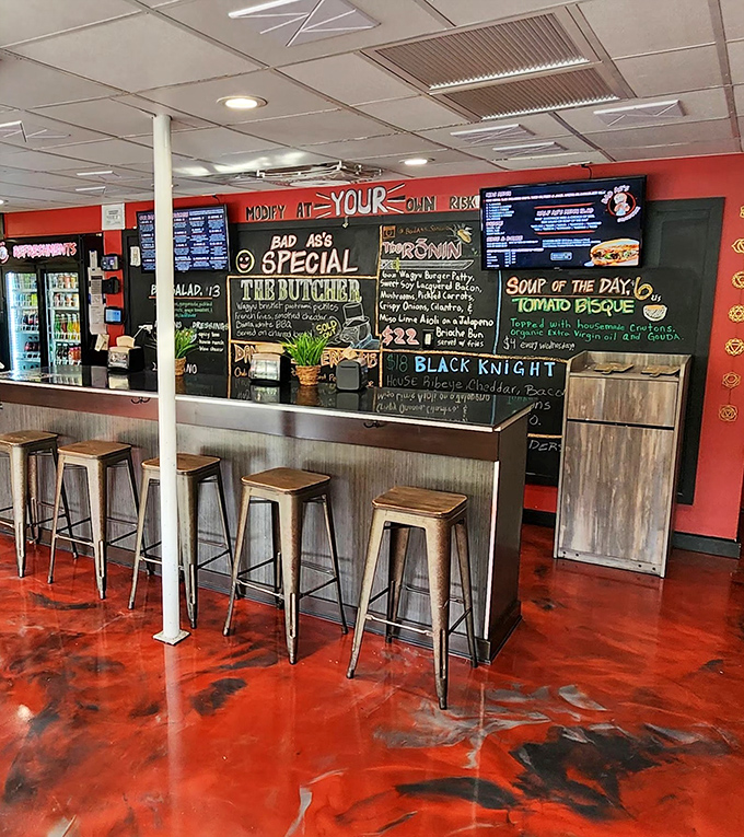 Industrial meets inviting with that striking red floor. The counter isn't just for ordering &ndash; it's front-row seating to culinary theater.