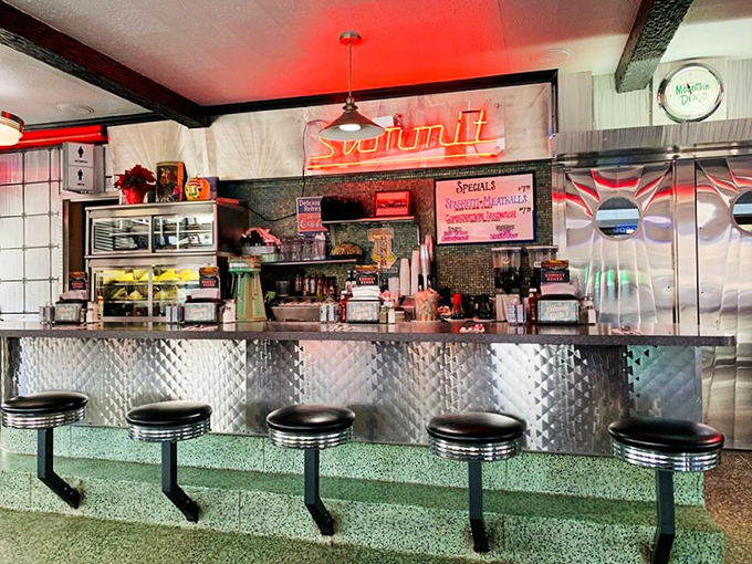 Classic diner counter where strangers become friends over shared appreciation for perfectly prepared comfort food and strong coffee.