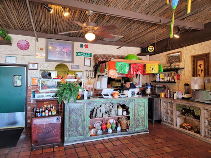 Behind this weathered green counter, culinary magic happens daily. The patina on that wood tells stories of thousands of satisfied customers.