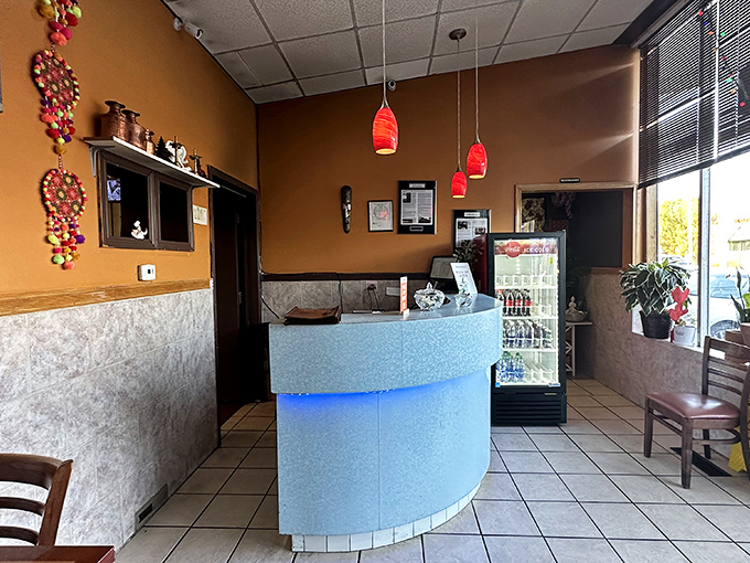 The curved reception counter glows with blue light, a modern touch in this temple of traditional flavors where culinary journeys begin.