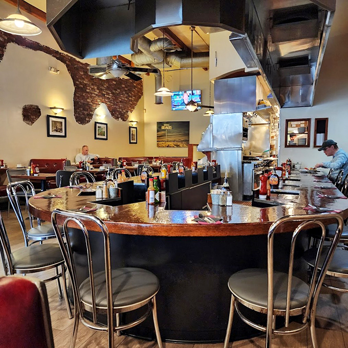 The curved counter offers prime real estate for solo diners and breakfast enthusiasts who appreciate watching culinary choreography in action.
