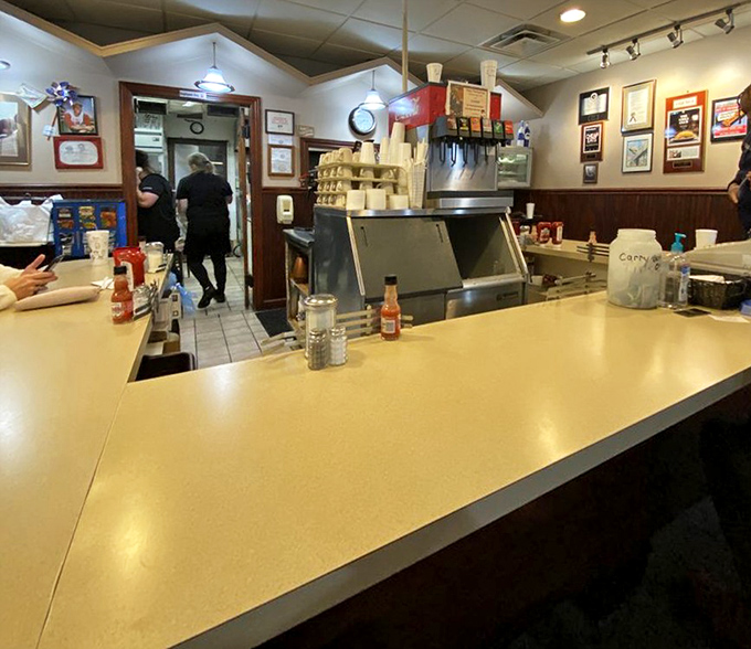 The counter where magic happens – yellow Formica, condiment bottles at the ready, and decades of diner history baked into every surface.