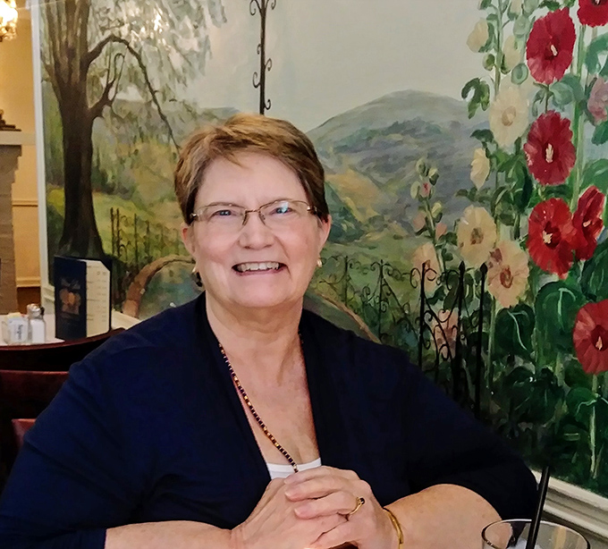 The dining room's wall mural creates a pastoral backdrop for meals that feel like a brief vacation from the modern world.