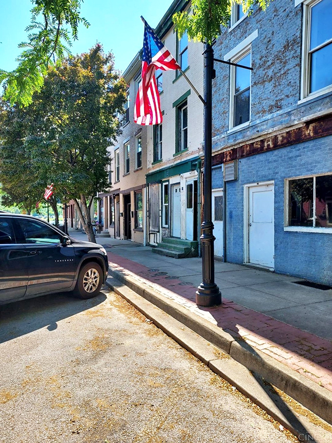 American flags flutter against historic storefronts, creating that perfect small-town tableau that Norman Rockwell would have rushed to paint.