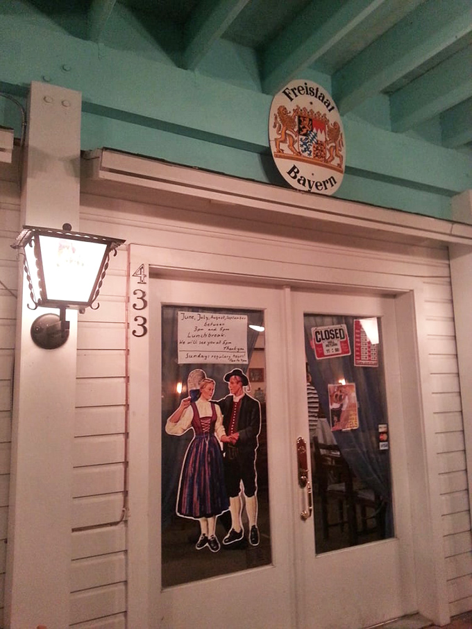 The entrance door, adorned with traditional Bavarian figures, stands as a portal between Florida sunshine and European comfort food paradise.