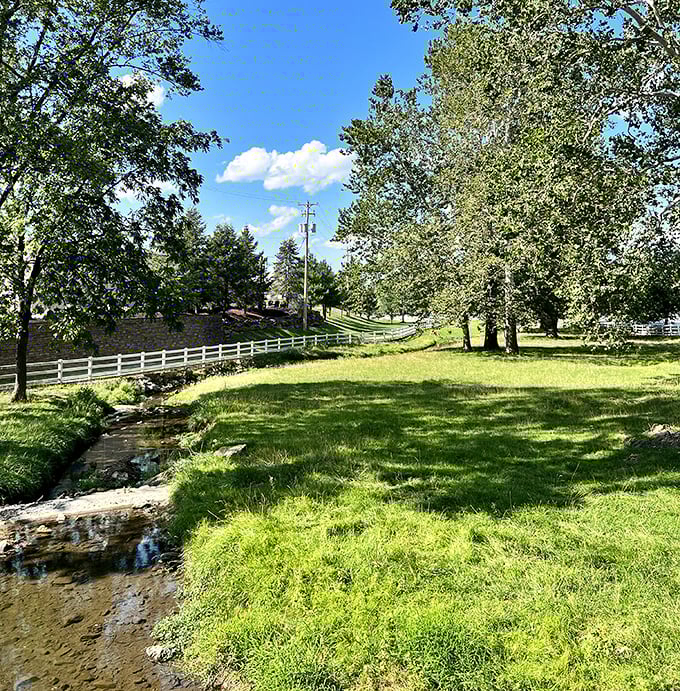 Beyond the bridge flows a pastoral scene straight from a landscape painting&mdash;white fences, green fields, and the ever-present gentle stream.