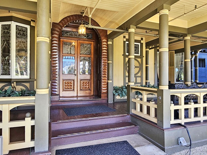 This elaborately carved front door, framed by an arched entryway, welcomes visitors with Victorian grandeur and a hint of mystery.
