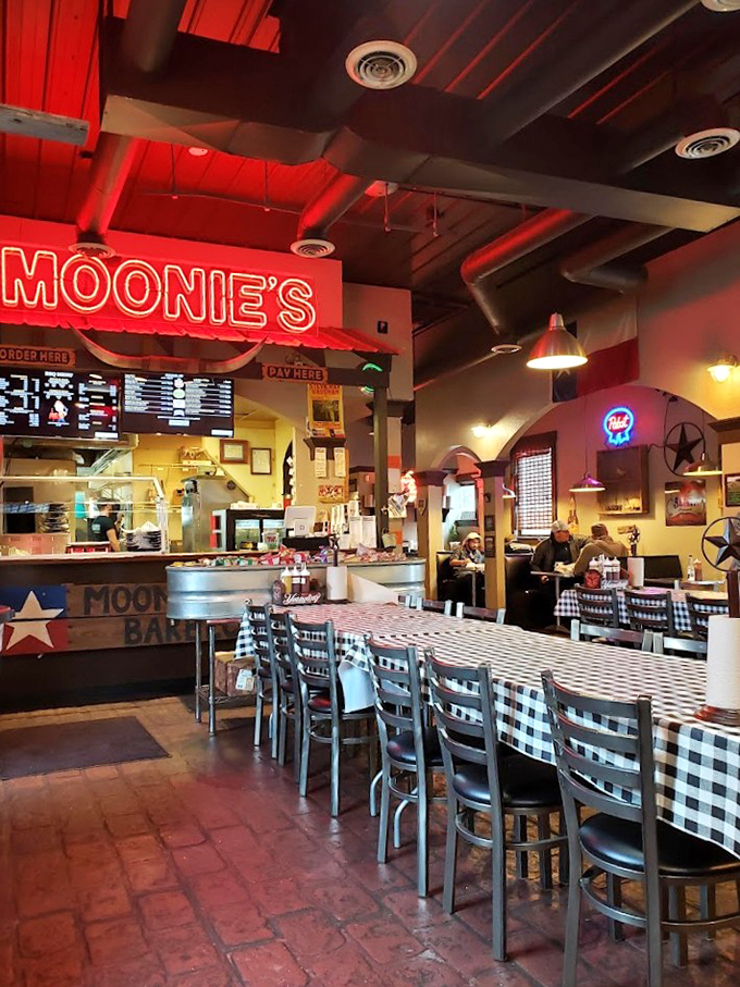 The dining room feels like Texas transported to Georgia, with checkered tablecloths and that glowing red sign promising smoky delights.