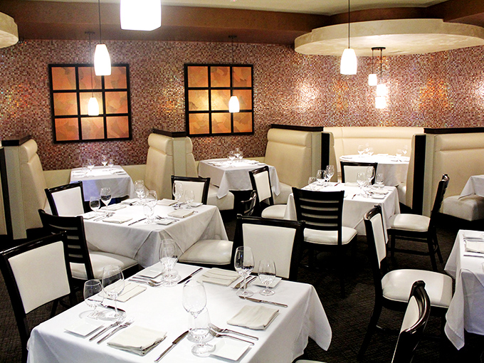 Mosaic walls and cream-colored booths create dining nooks that feel both intimate and luxurious, like your own private culinary sanctuary.