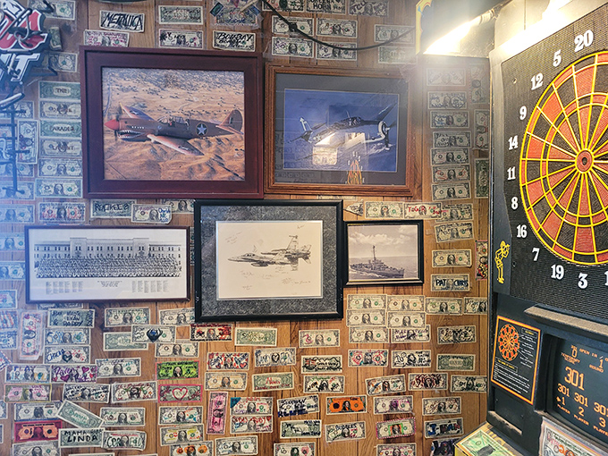 Military photos and dollar bills create a museum of memories, where every frame tells a story of those who passed through.