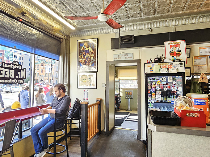 The counter seating offers front-row tickets to the sandwich show. Red ceiling fan spinning overhead like a timekeeper of beef traditions