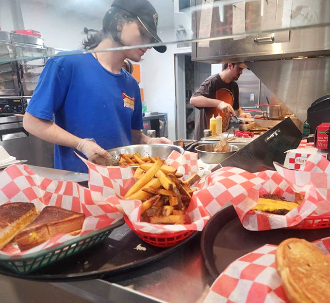 The kitchen ballet &ndash; where hot dog dreams become reality. Those hands have likely prepared thousands of meals, each with the same care as the first.