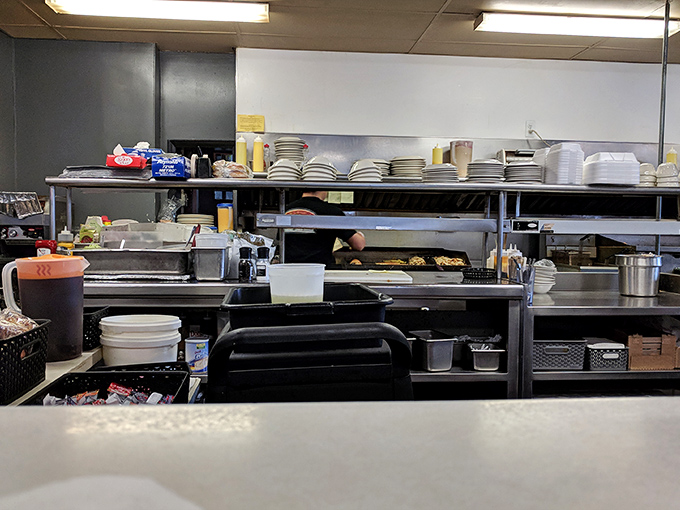 The engine room of breakfast perfection. Stacks of plates waiting for their moment to shine, while skilled hands transform simple ingredients into memories.