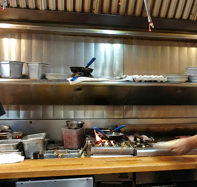 The kitchen pass&mdash;where breakfast alchemy happens. That flat-top grill has probably seen more action than the entire Marvel universe combined.