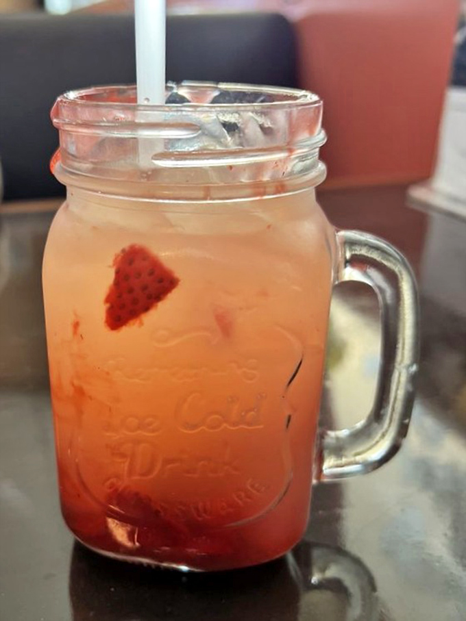 A mason jar of strawberry lemonade that looks like summer decided to take liquid form just to brighten your day.