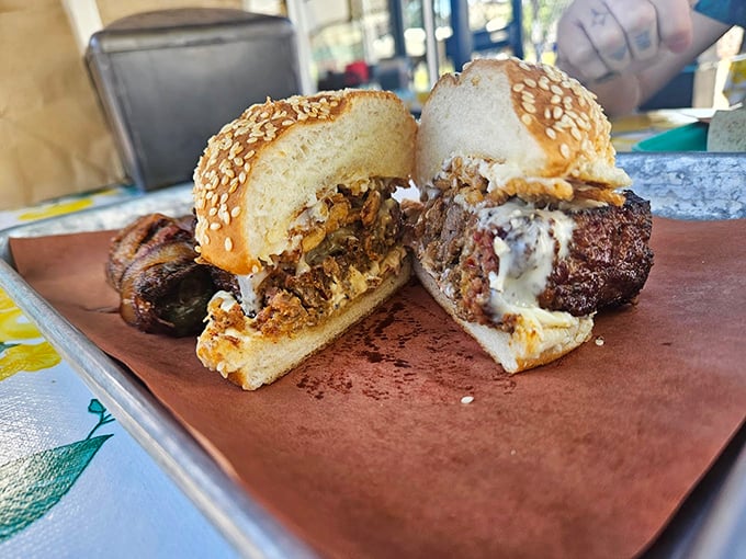 A sandwich that demands to be photographed, then immediately devoured. The sesame bun barely contains the meaty masterpiece within.