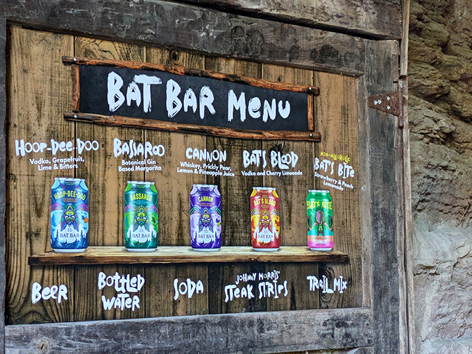 The rustic menu board displays specialty cocktails with names that perfectly capture the cave's playful spirit.