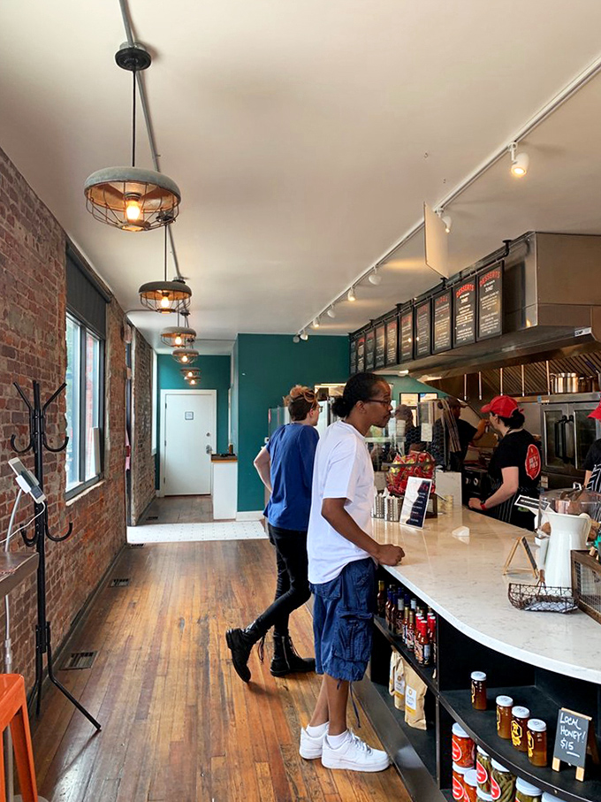 The interior speaks volumes: warm wood, exposed brick, and industrial lighting create a space where the food remains the undisputed focus.