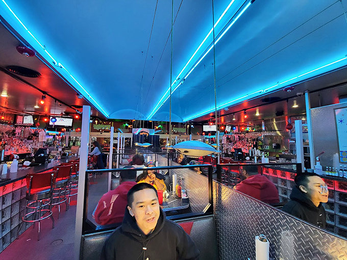 Blue neon ceiling lights guide you through the diner like runway lights for your taste buds. The red booths beckon with promises of comfort.
