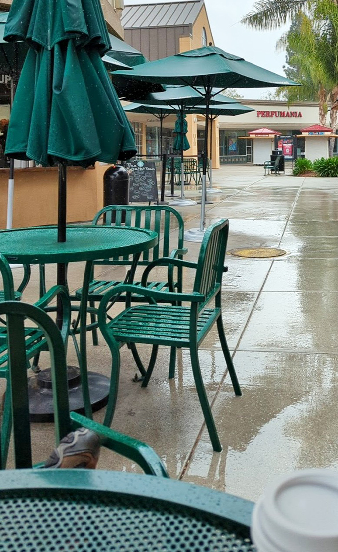 Rain can't dampen the outlet experience. These emerald chairs await tired shoppers needing a moment to contemplate their next retail conquest.