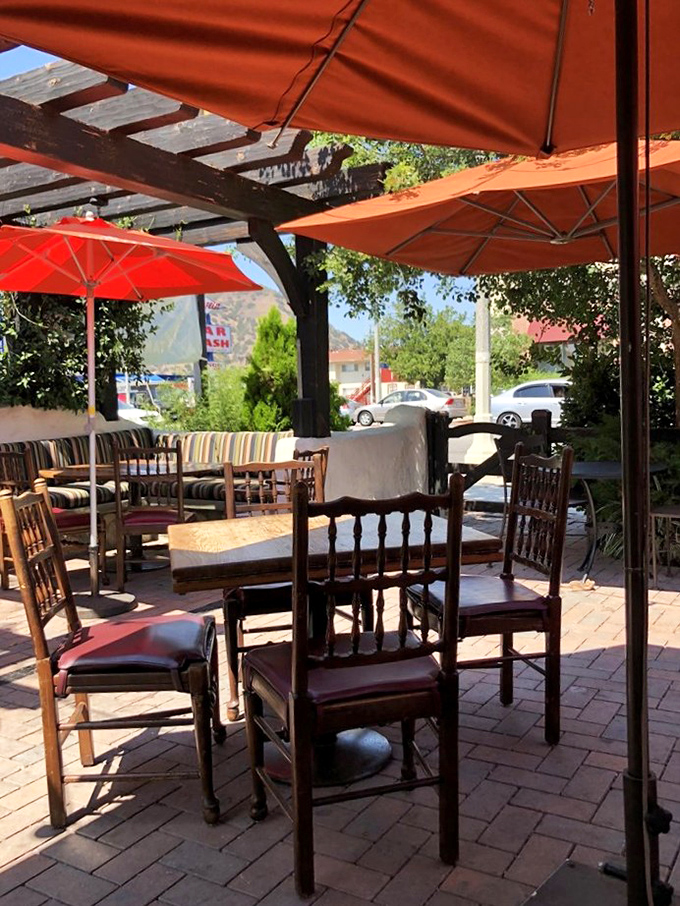 Wooden chairs with character and brick pavers underfoot—outdoor seating that feels both rustic and refined, like dining at a country estate.