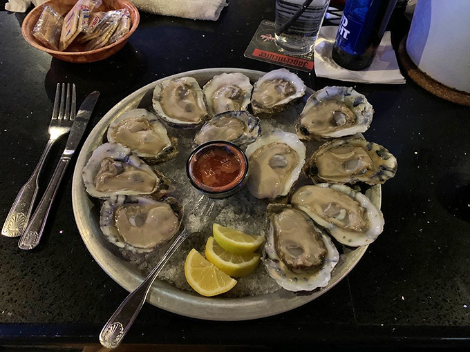 A dozen fresh oysters on the half shell, nature's perfect appetizer served with cocktail sauce and lemon wedges.