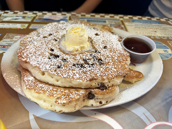 Pancakes so fluffy they practically hover above the plate, crowned with butter and powdered sugar like breakfast royalty.