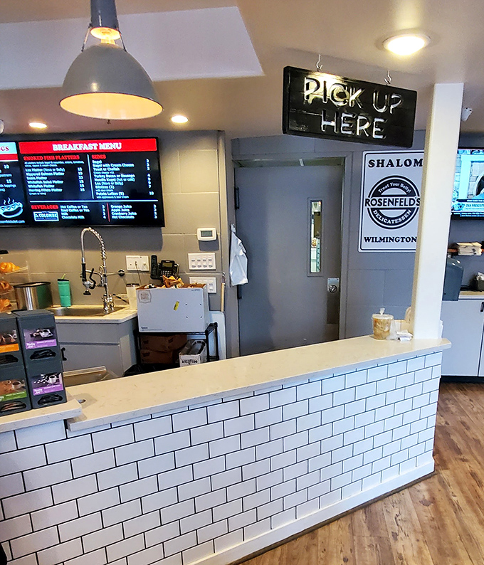 The "Pick Up Here" sign glows like a North Star for hungry pilgrims. Behind that counter, paper-wrapped treasures await their rightful owners.