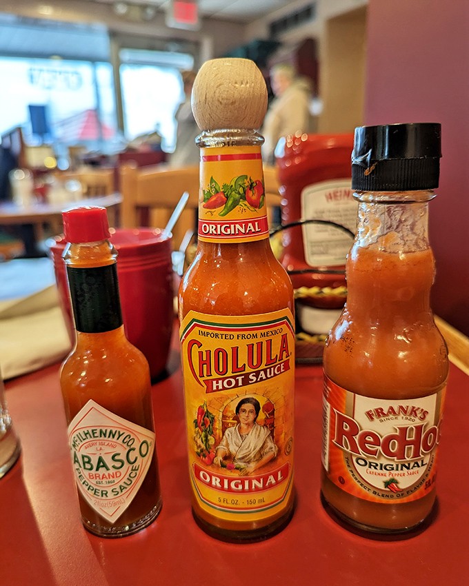The hot sauce trinity—Tabasco, Cholula, and Frank's—ready to transform your eggs from "pretty good" to "where have you been all my life?"