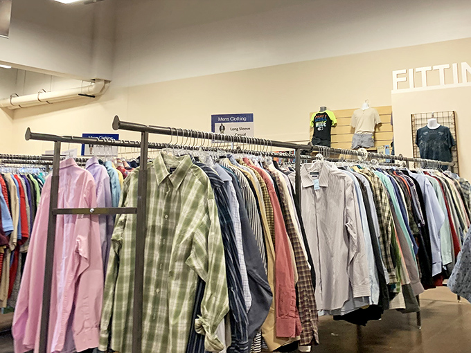 Men's dress shirts hang in perfect formation, offering professional wardrobes at unbeatable thrift store prices.