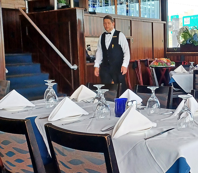 The staff prepares for service with the precision of a Broadway cast, each table a stage waiting for the evening's culinary performance.