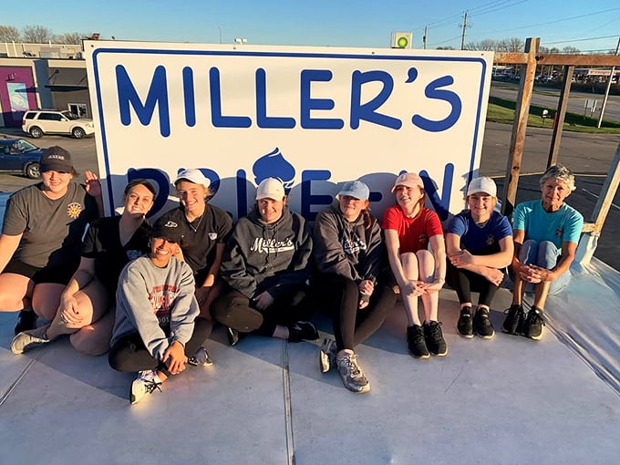 The team behind Miller's poses proudly by their sign&mdash;these are the keepers of the flame, the guardians of good taste in small-town America